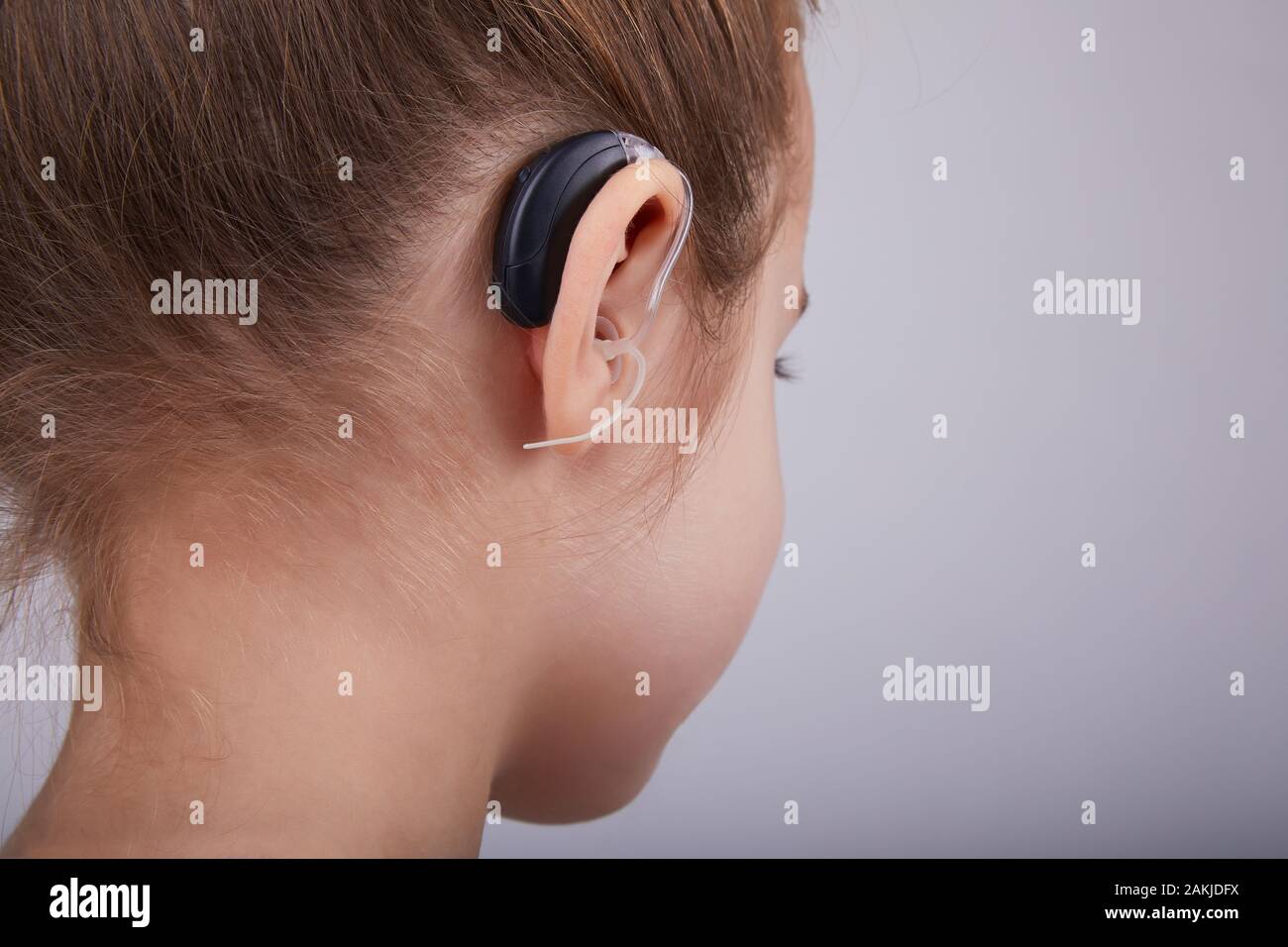 Hearing Aid in Young Girl's Ear. Toddler girl wearing a hearing aid ...