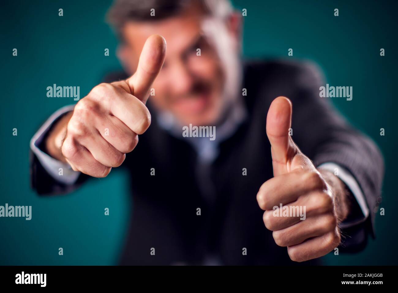 Businessman in suit showing thumb up symbol. Success concept Stock ...