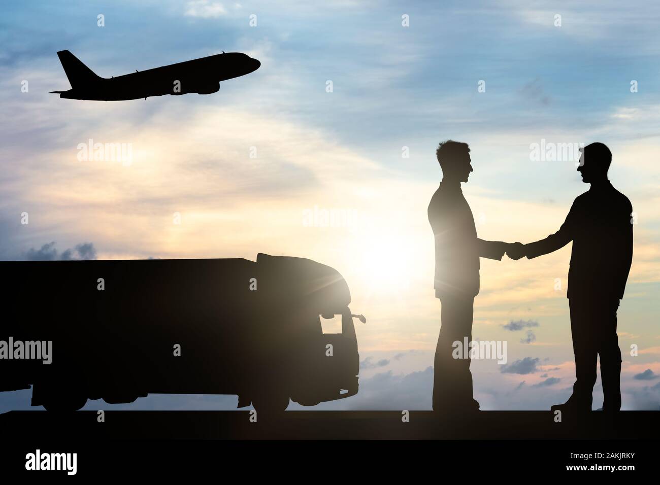Silhouette Of Two Businessmen Shaking Hands Near Commercial Truck And ...