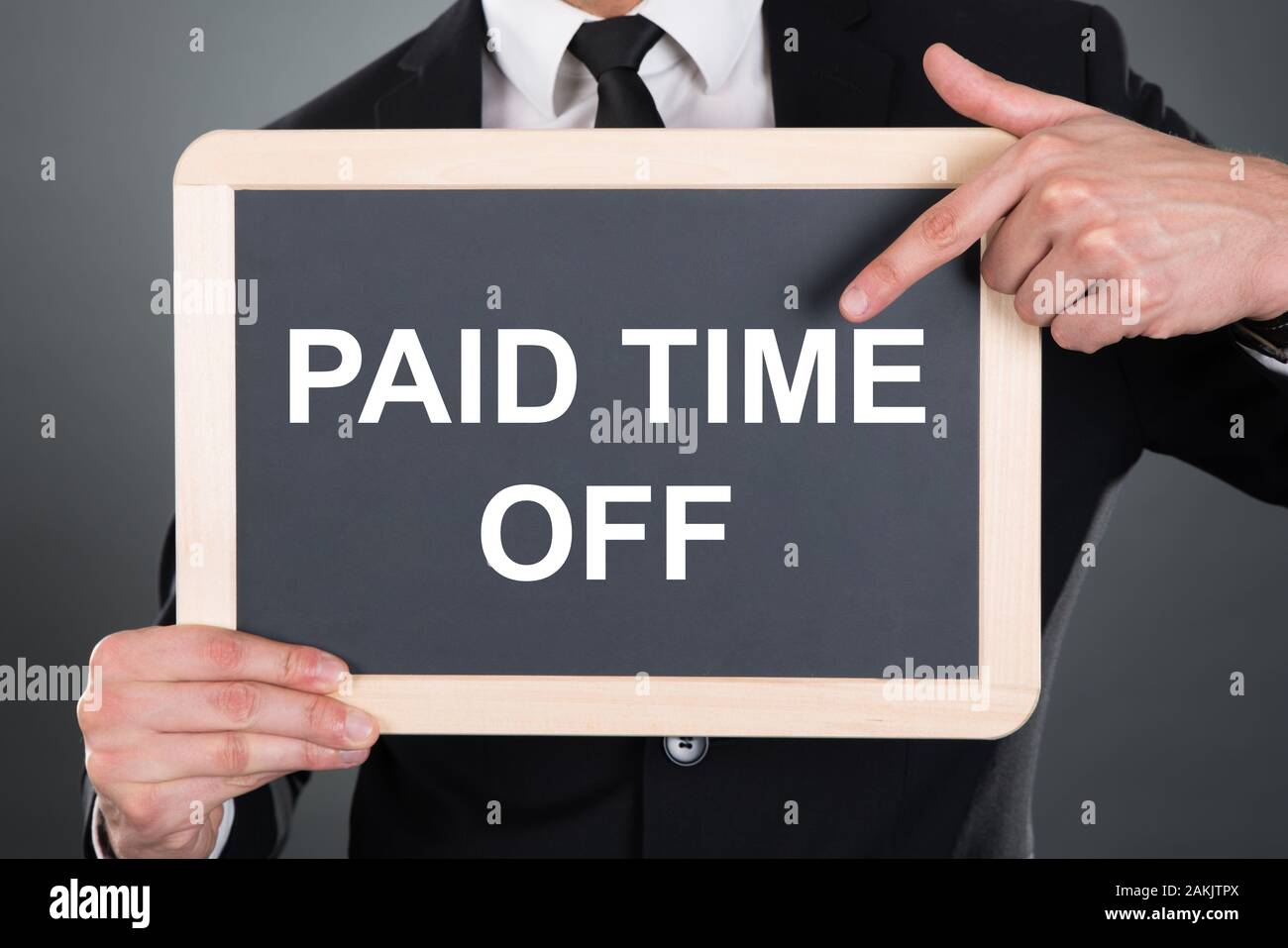Midsection Of A Businessman Pointing At Paid Time Off Text Over Black ...