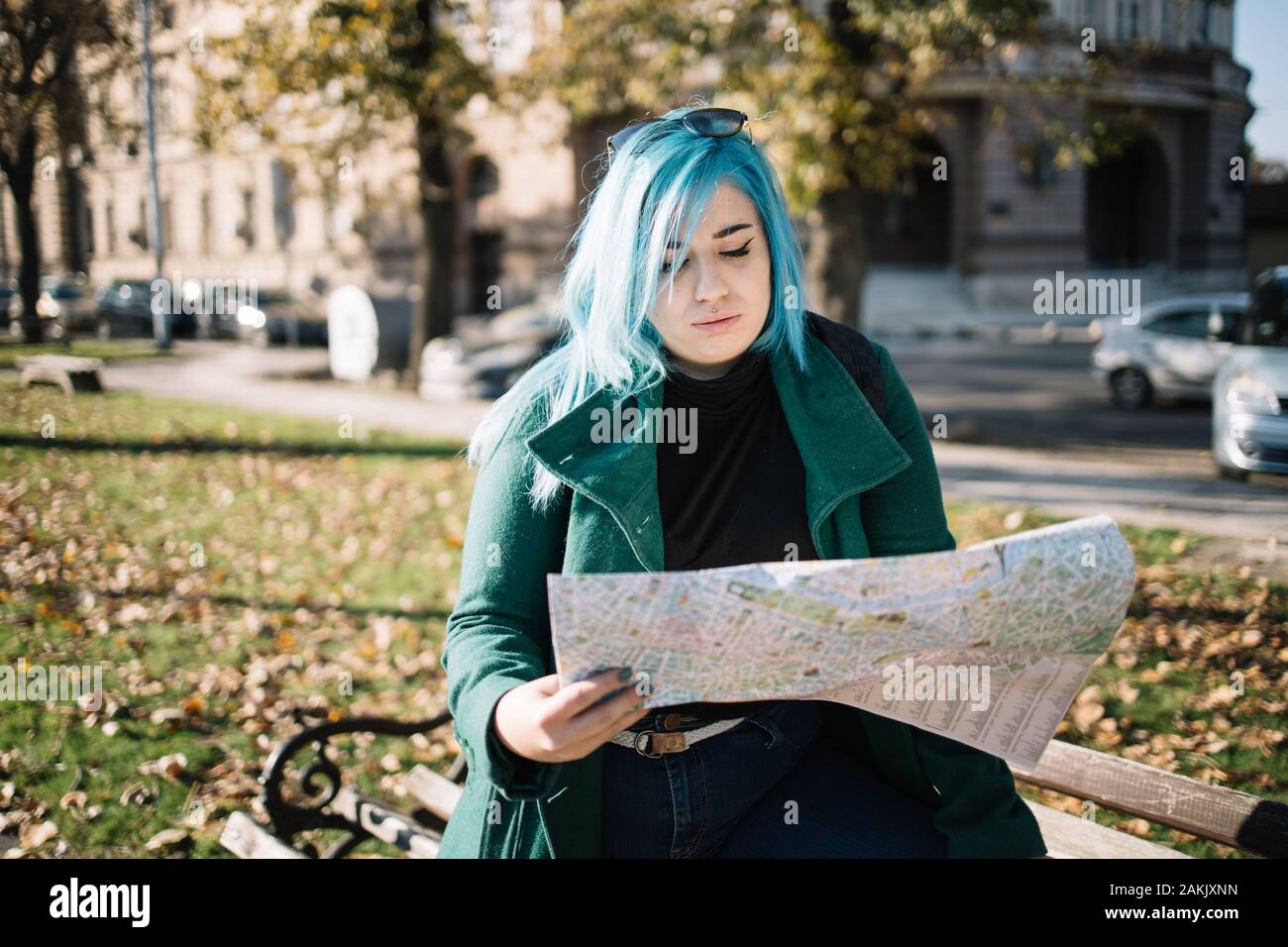 Explorer woman holding a map and walking on street Stock Photo - Alamy