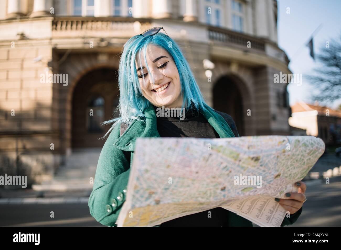 Smiling girl searching for location on a map Stock Photo - Alamy