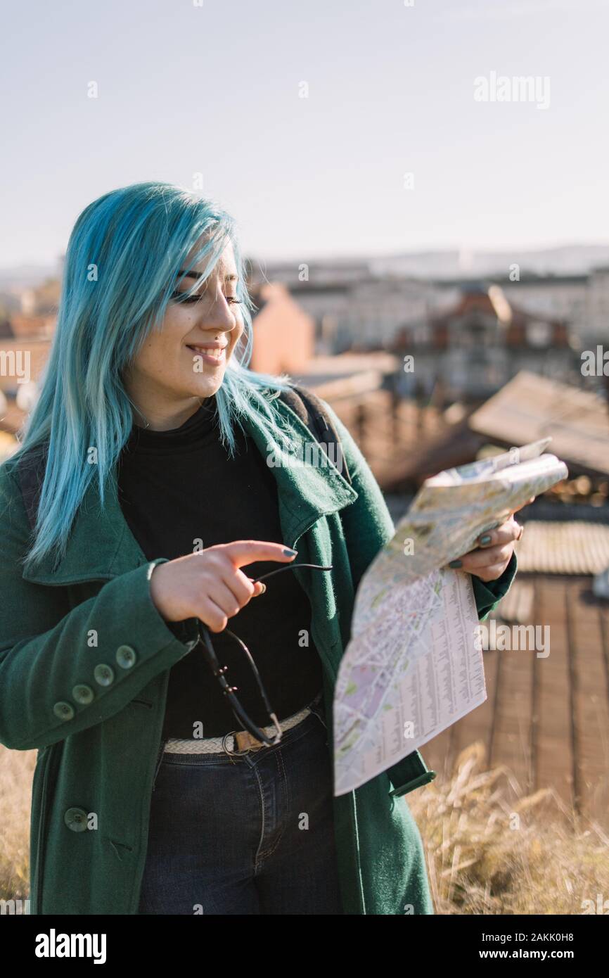 Smiling girl looking for direction on paper map Stock Photo - Alamy