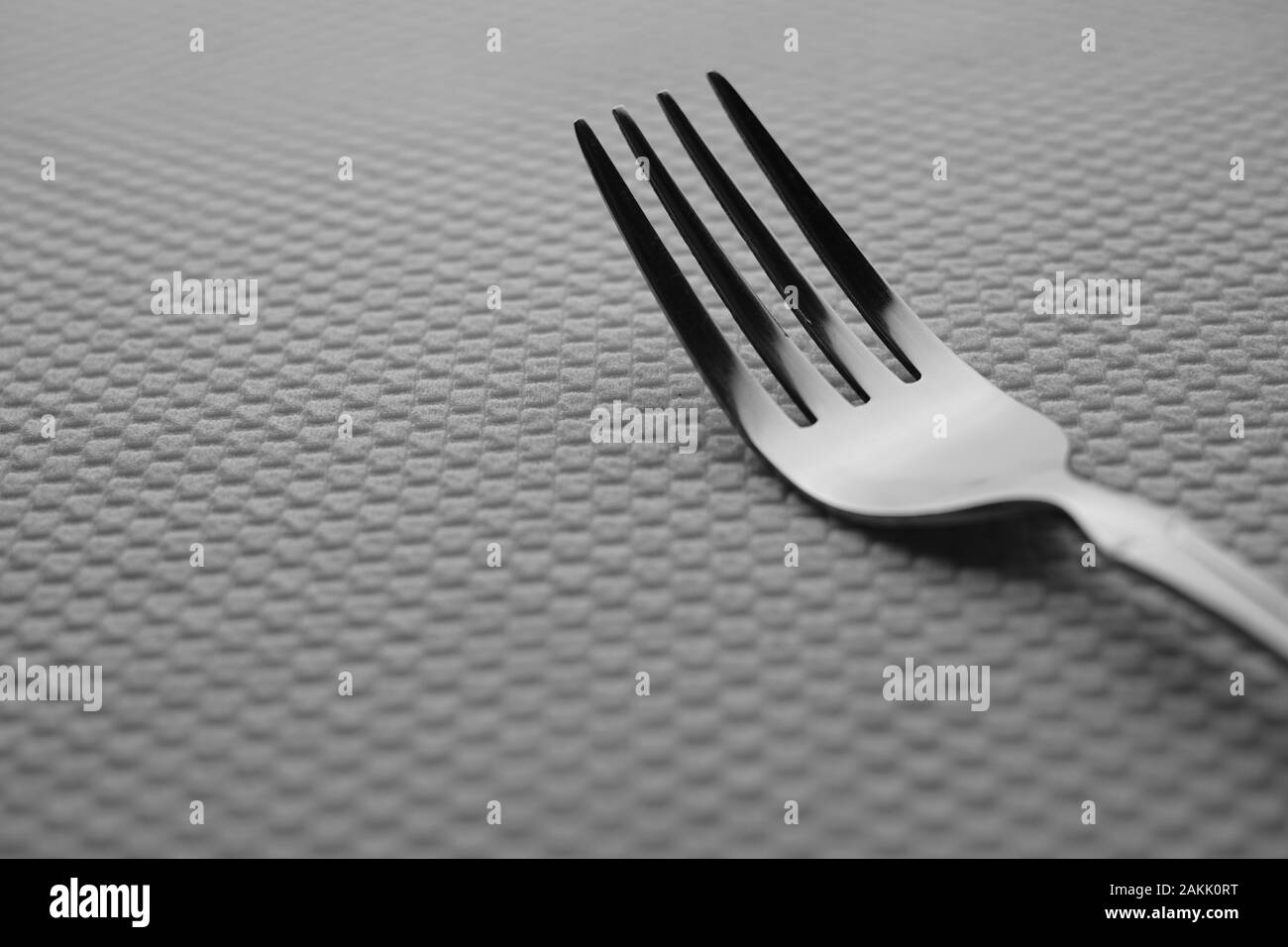 Modern silver stainless steel fork on a white table Stock Photo - Alamy