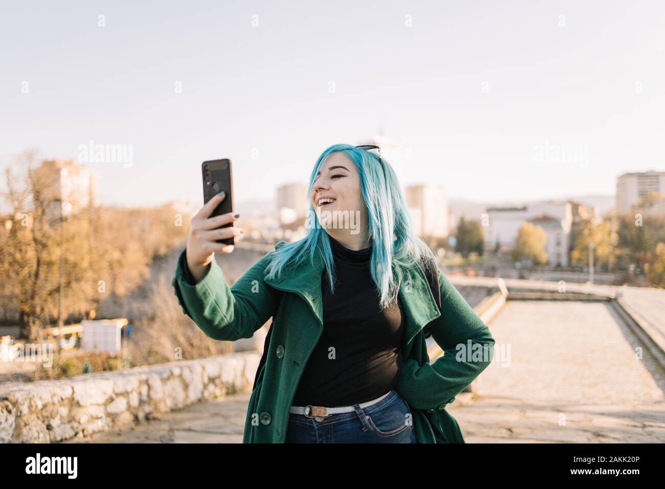 Attractive girl with dimples taking photo of herself Stock Photo - Alamy