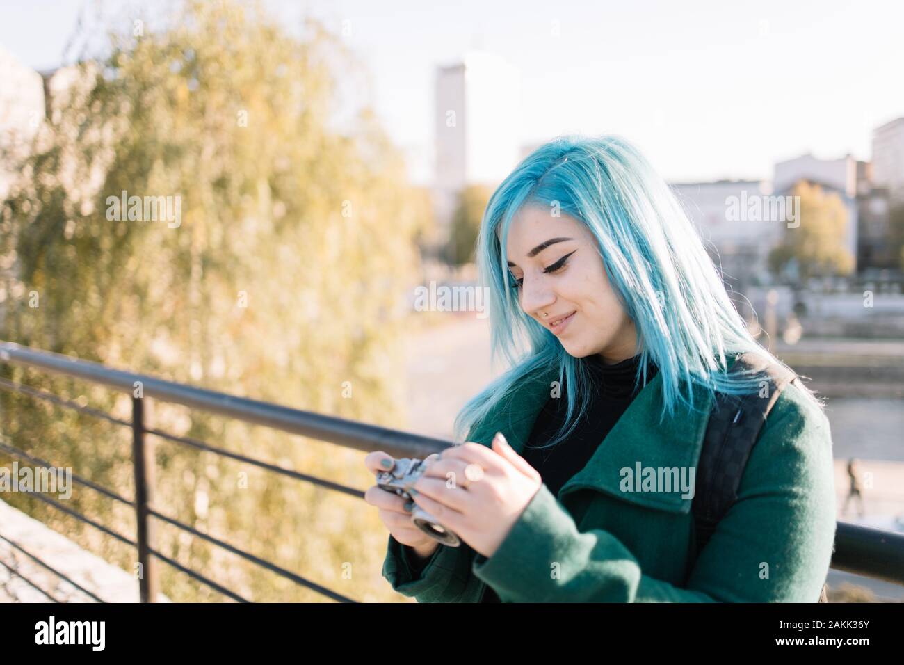 Girl with blue hair checking fotocamera's photos Stock Photo - Alamy