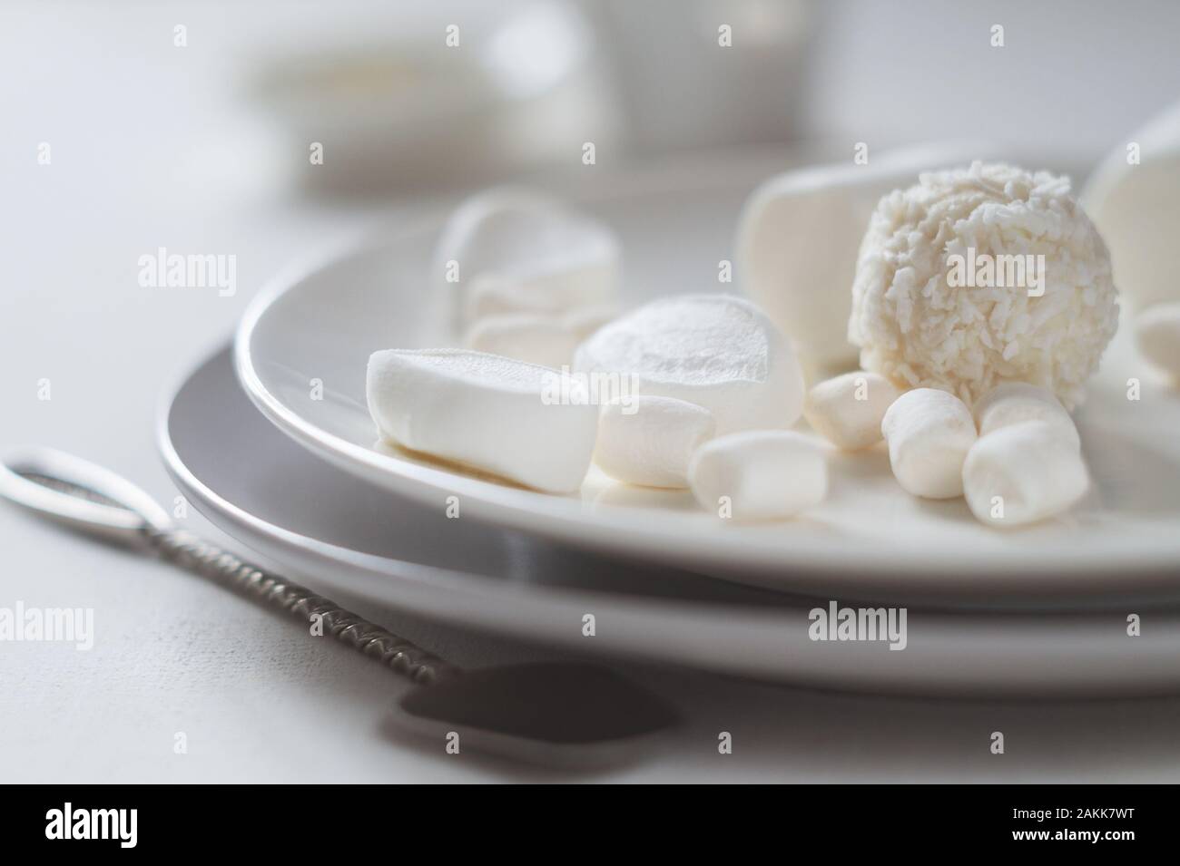 Various white sweets, marshmallows and a spoon with peanut butter on a ...