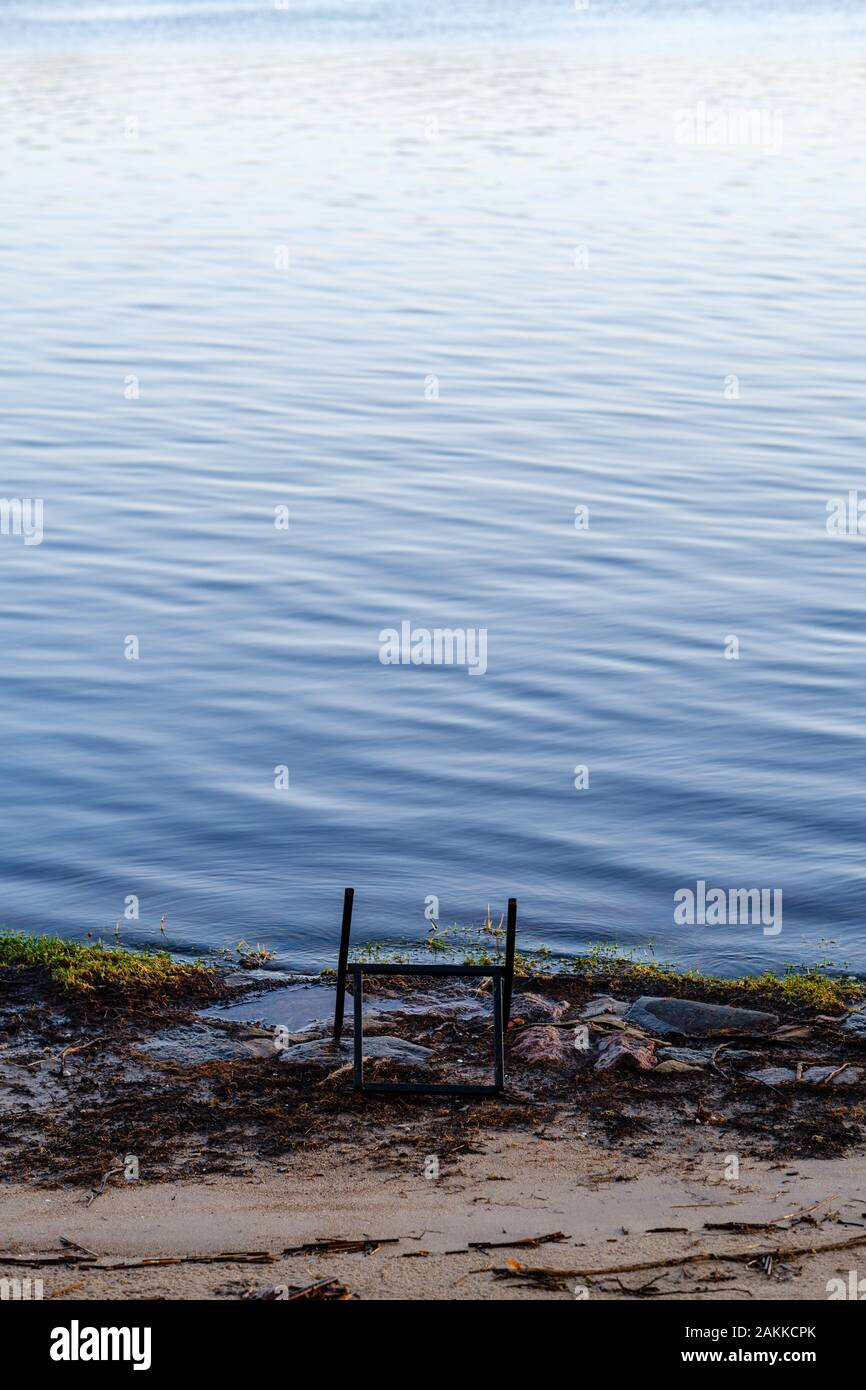 empty sea beach in autumn with some bushes and dry grass. water in ...