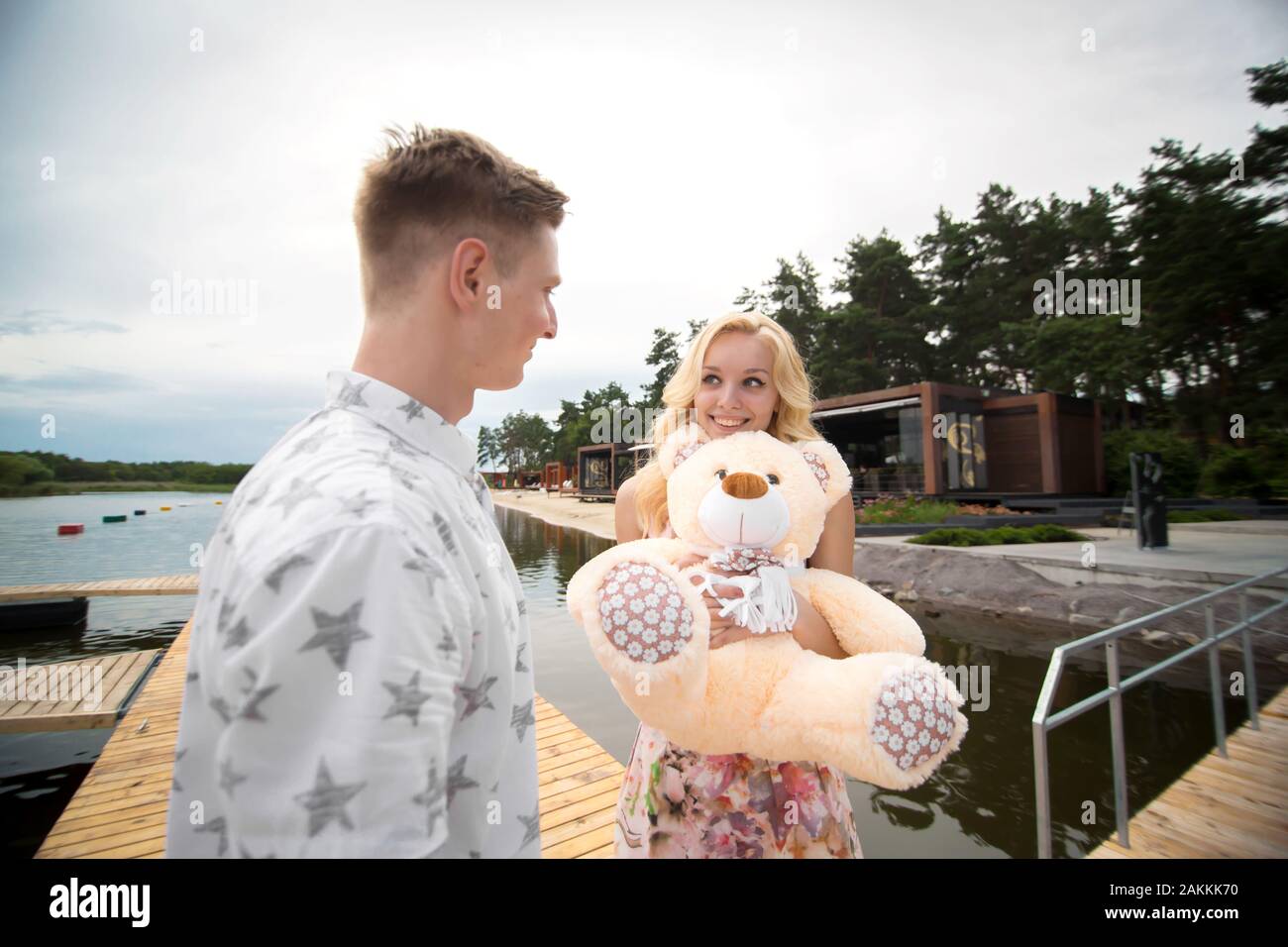 Romantic date surprise. A young guy and a girl on a pier overlooking ...