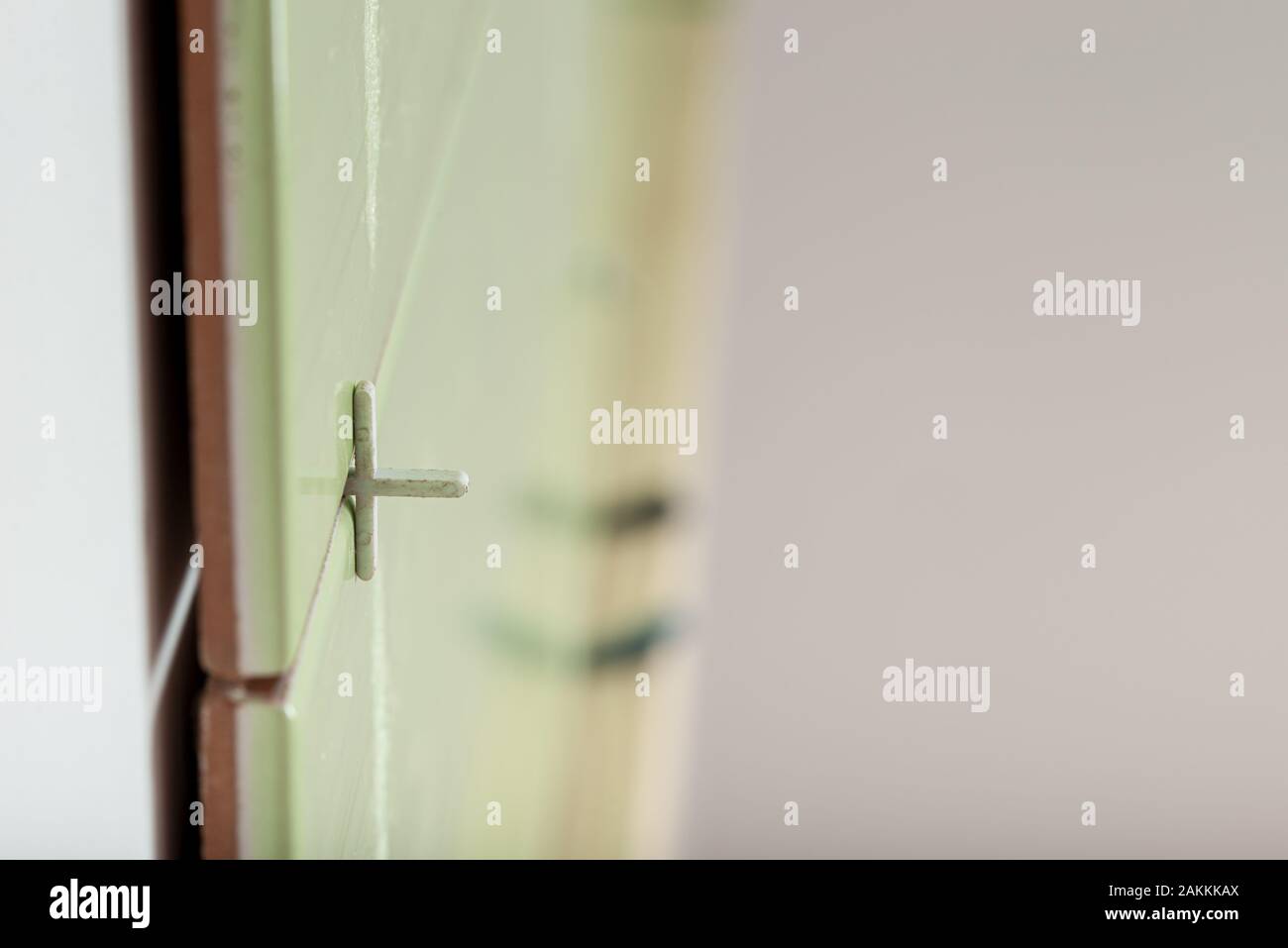 Closeup of unfinished green ceramic tiles with tile spacers. Concept of ...