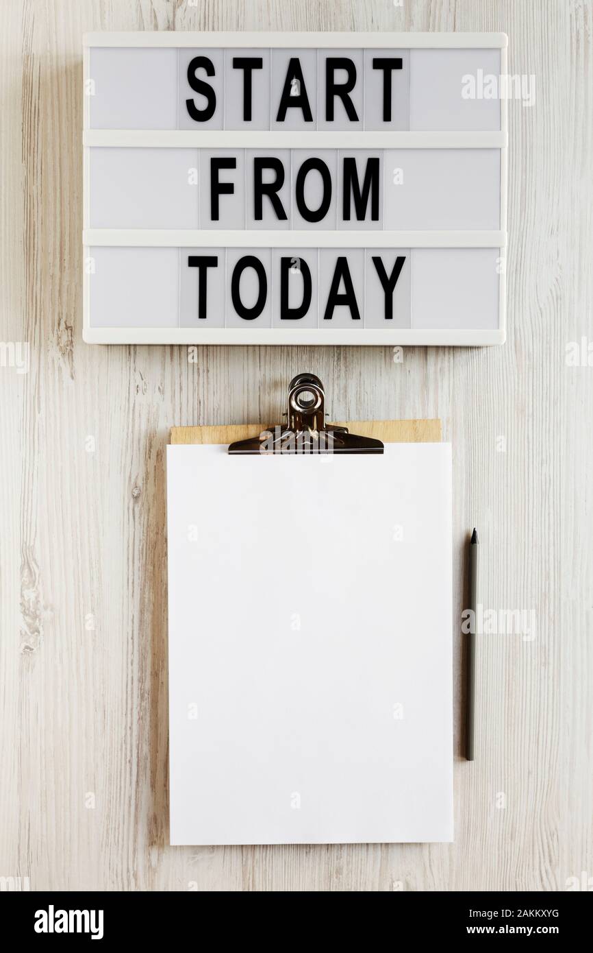 'Start from today' words on a lightbox, clipboard with blank sheet of ...