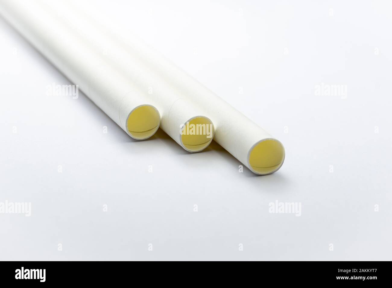 Close up white paper straws laying flat isolated on white background ...