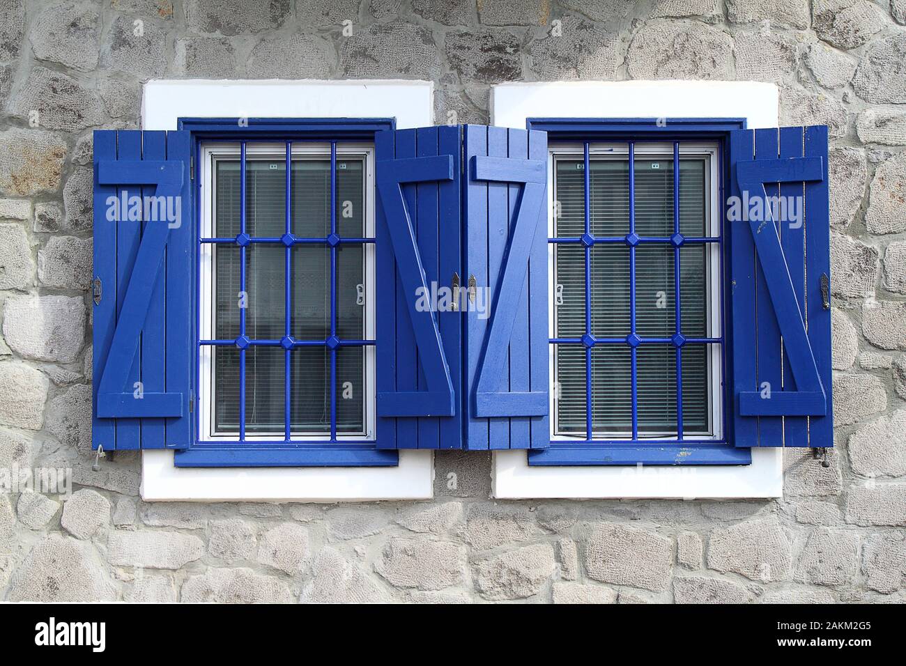 Open and closed light blue wooden window blinds on windows of newly ...