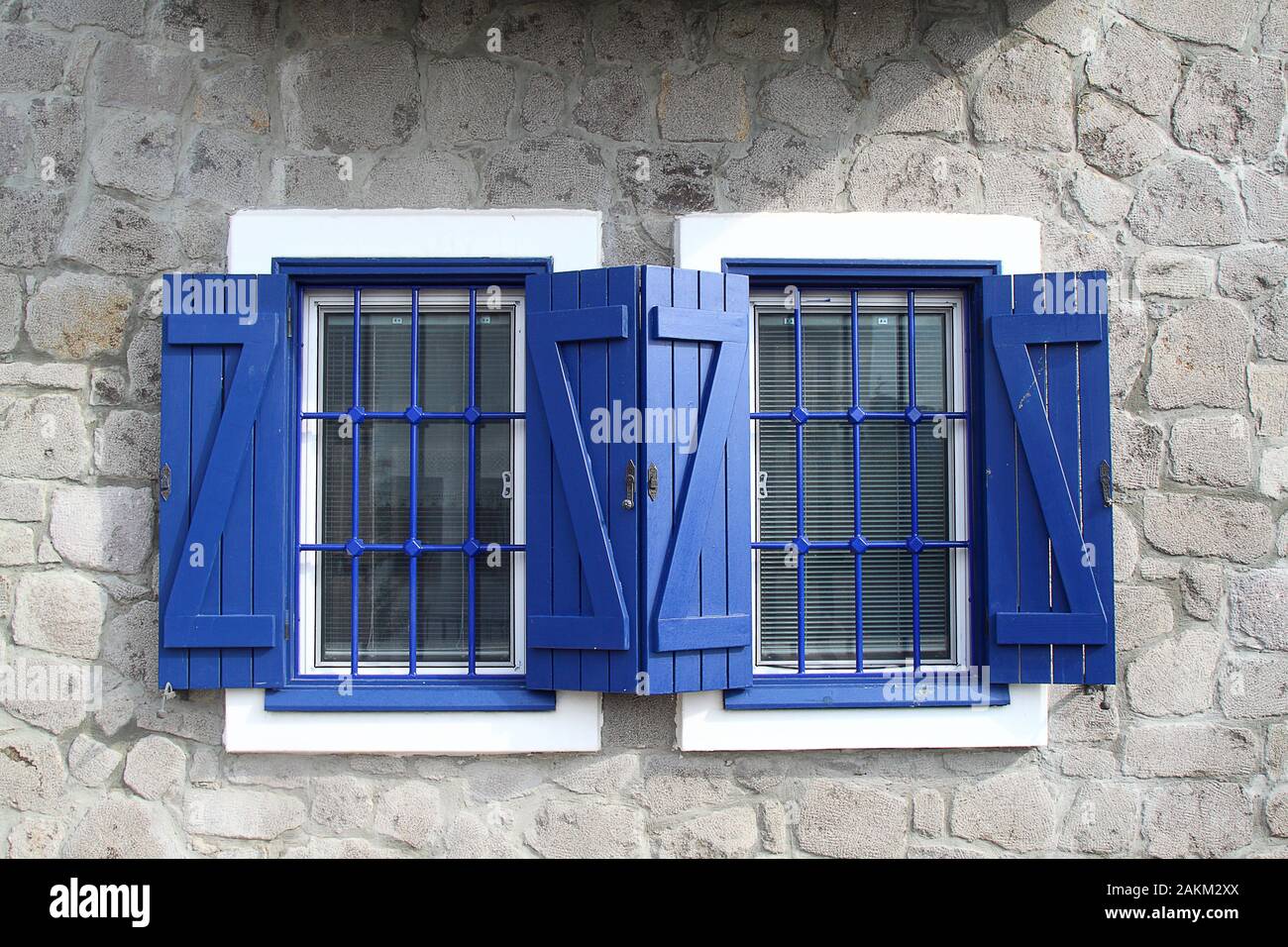 Open and closed light blue wooden window blinds on windows of newly ...