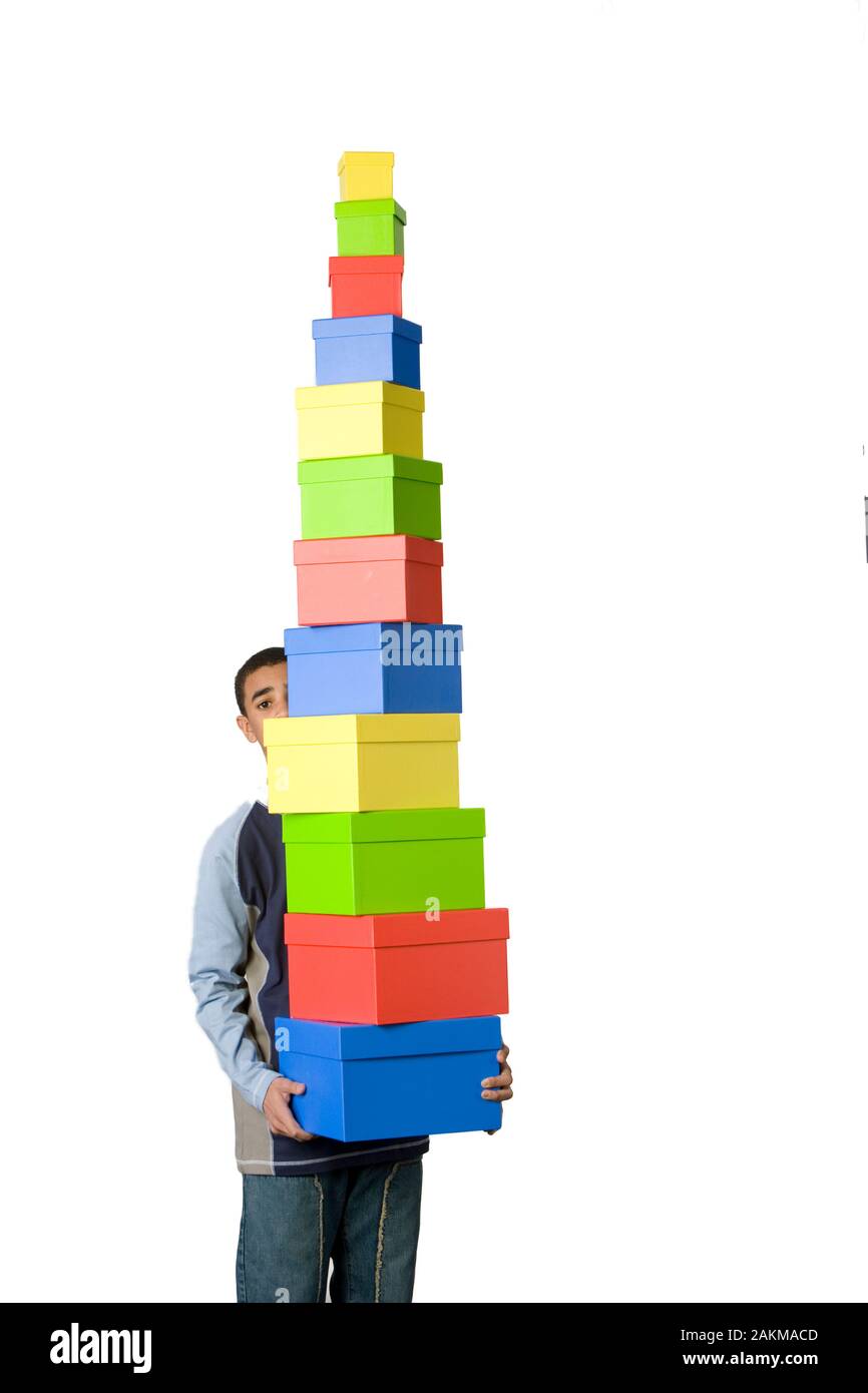 African-American Teenager balancing a stack of colored boxes isolated ...