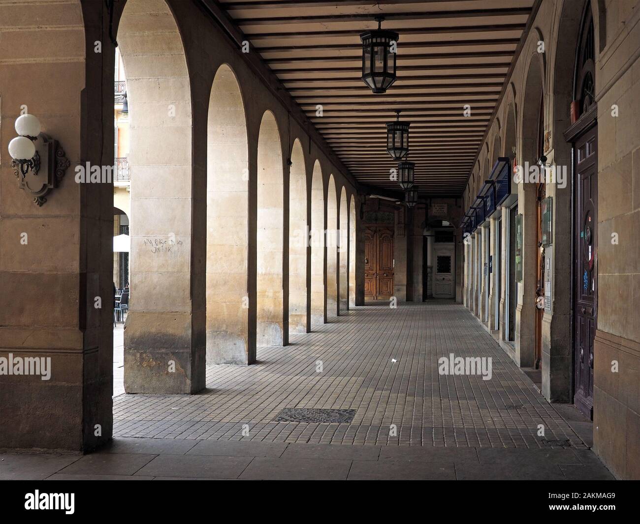 glimpse of a city square through receding arches alongside the covered ...