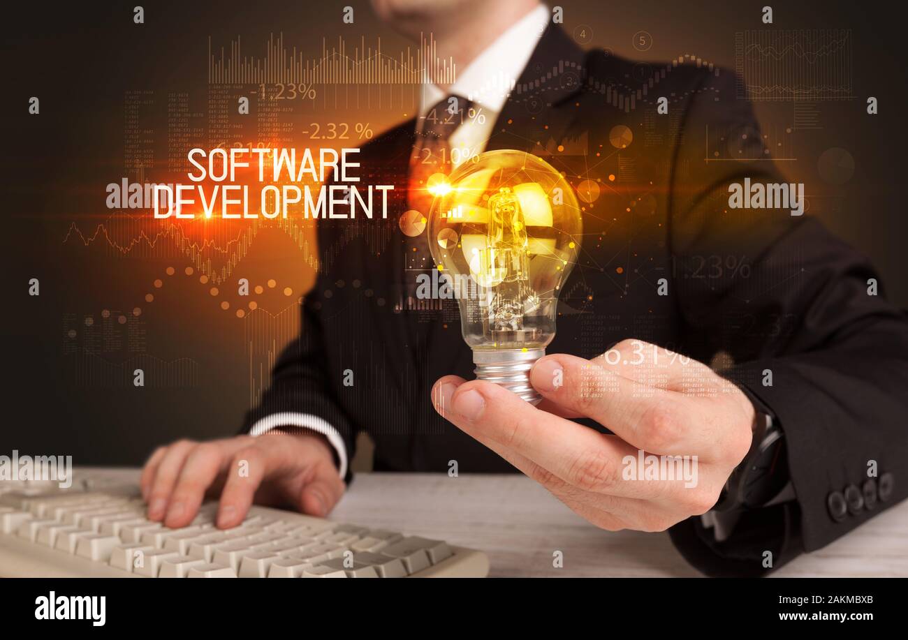 Businessman holding lightbulb with SOFTWARE DEVELOPMENT inscription, Business technology concept ...