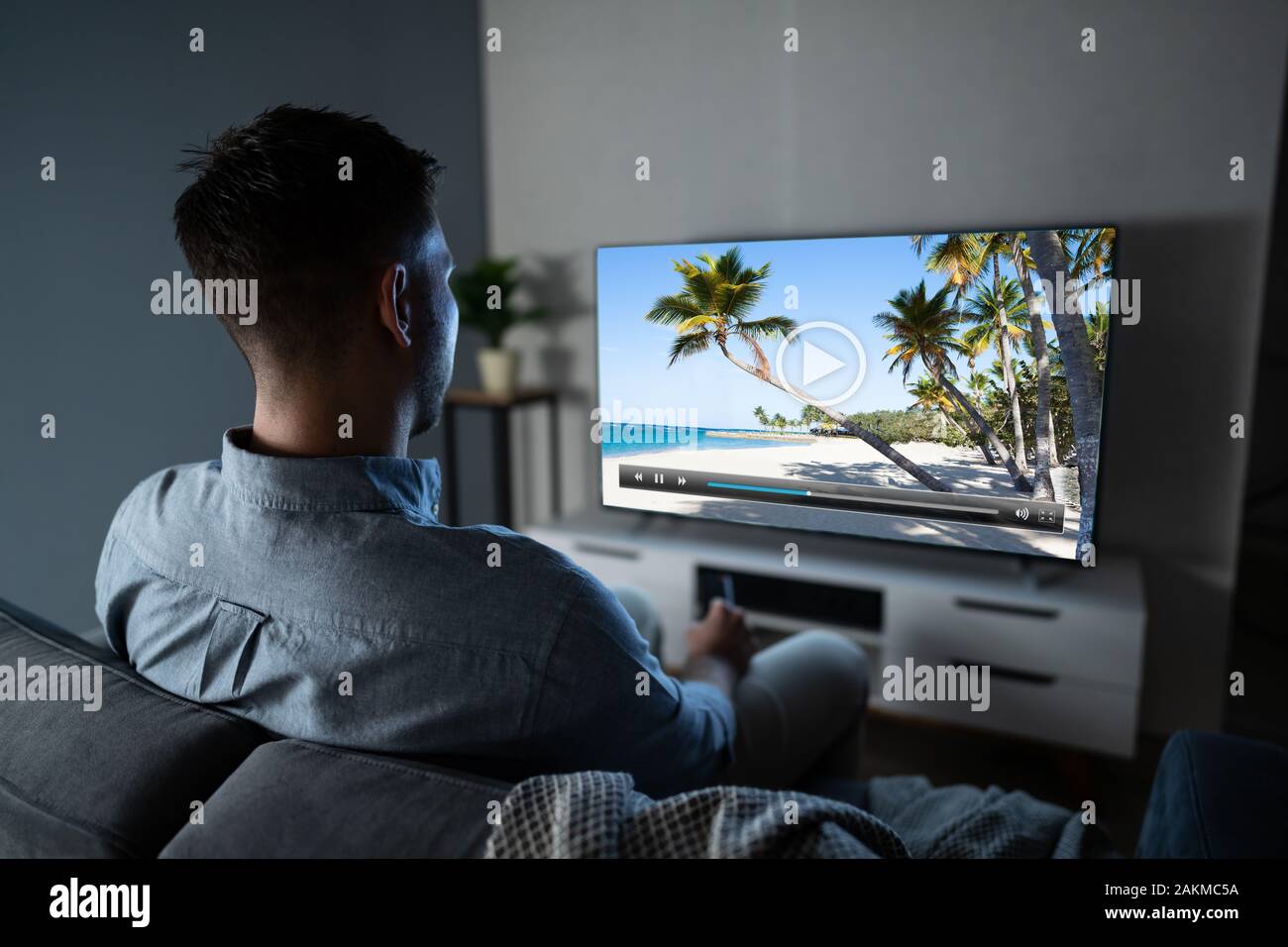 Rear View Of A Man Sitting On Couch Watching Television Stock Photo - Alamy