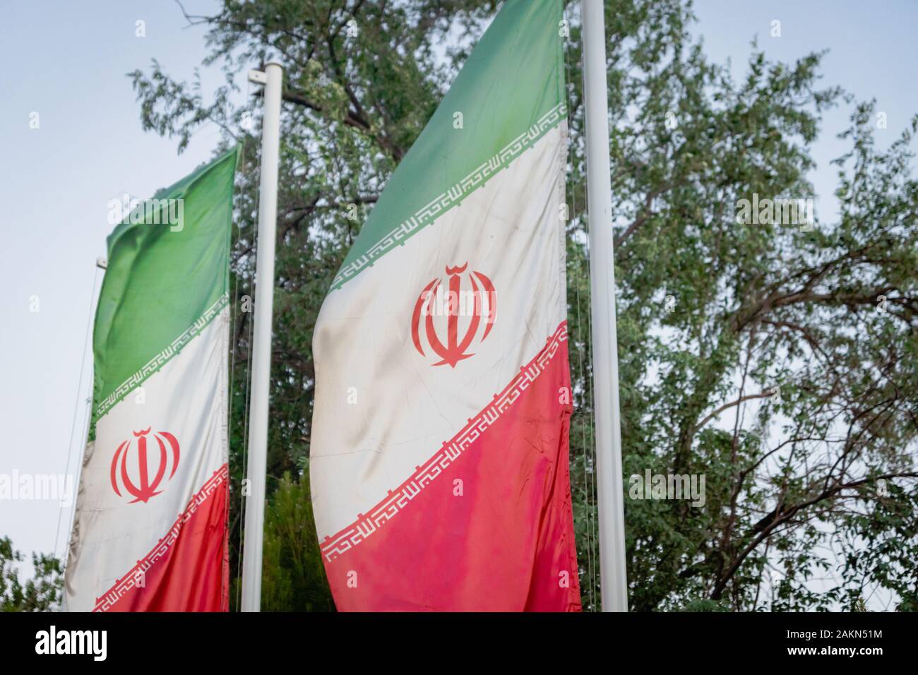 Iranian flags, flags of Islamic Republic of Iran, waving against blue ...