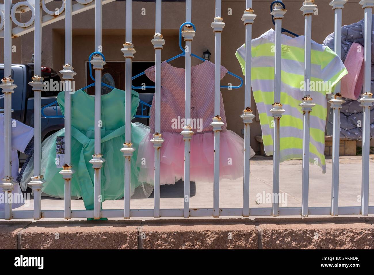 children's clothing hanging on fence Stock Photo - Alamy