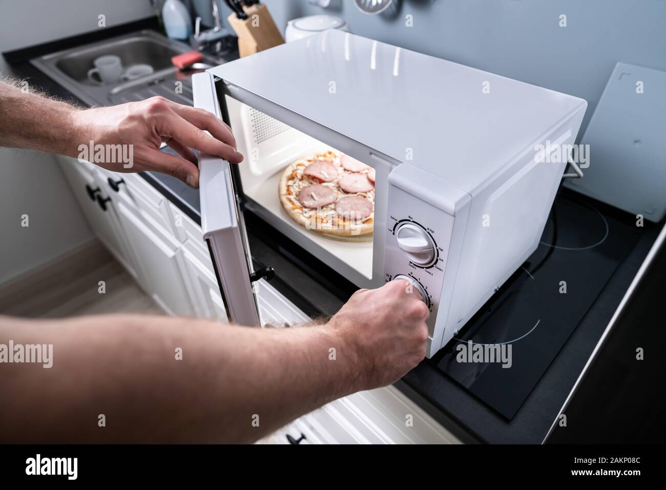 Human Hand Baking Pizza In Microwave Oven Stock Photo - Alamy