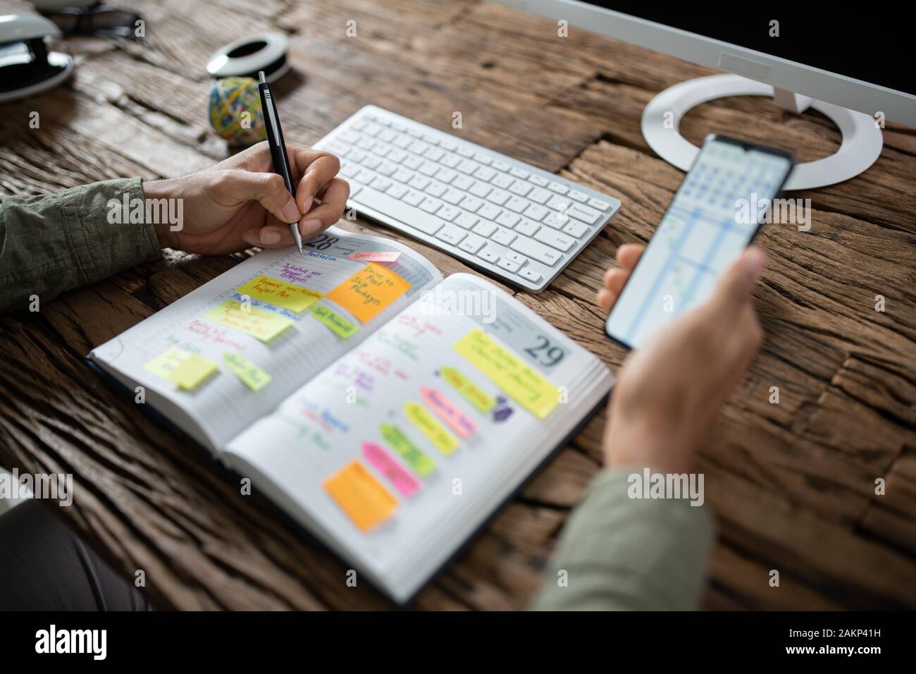 Close-up Of Businessman Writing Schedule In Calendar Diary On Desk ...