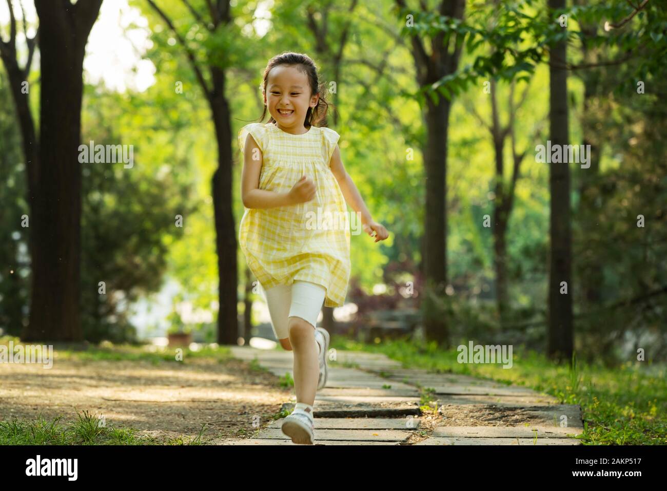 The little girl is running in the park Stock Photo - Alamy