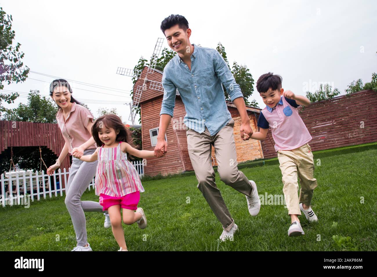 Happy family run on the grass Stock Photo - Alamy