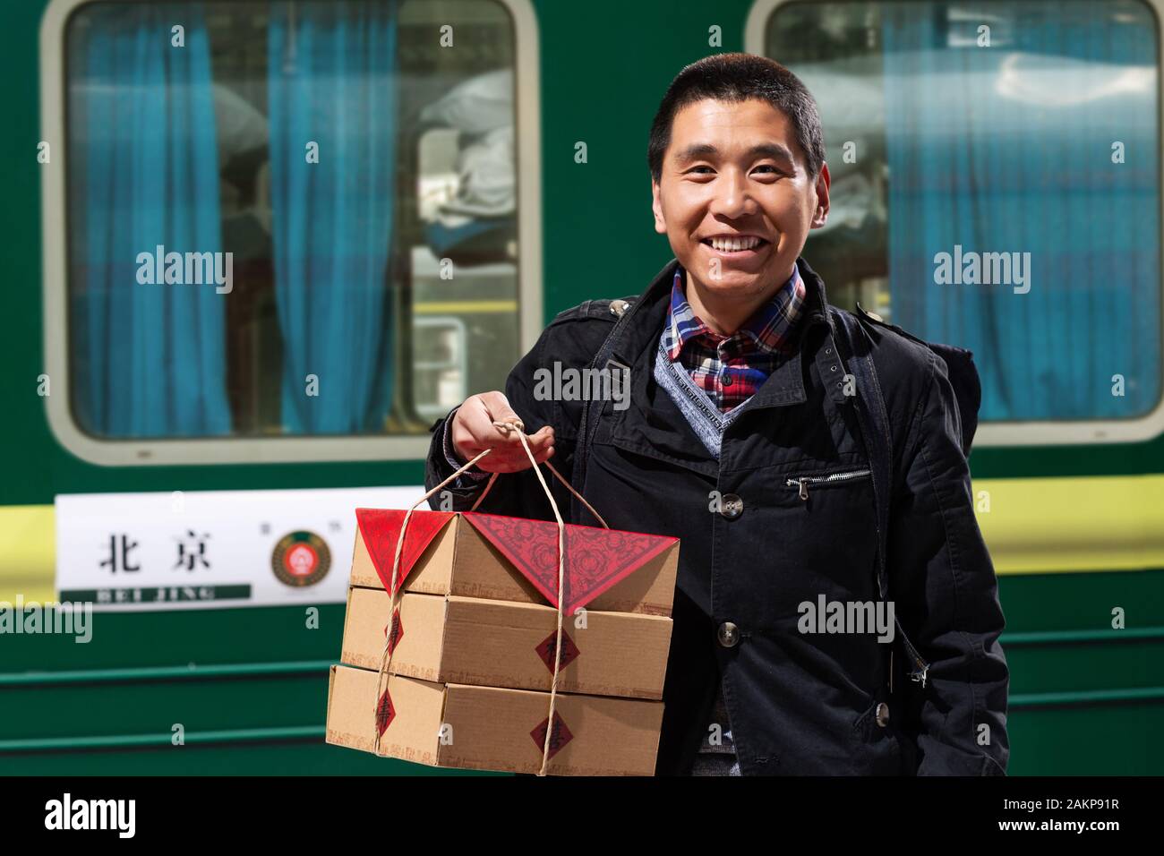 Passengers stand on stage at the train station Stock Photo - Alamy