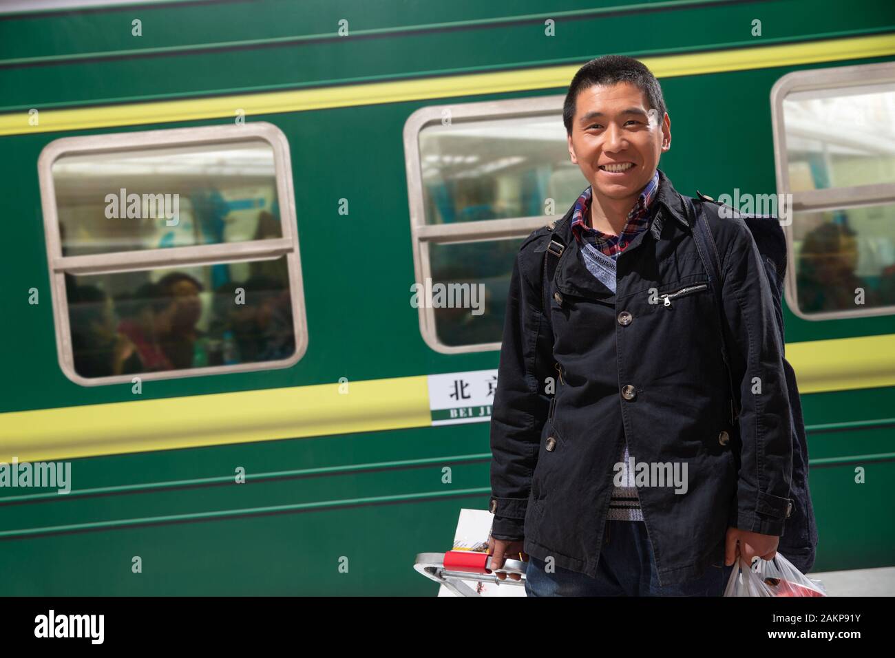 Passengers stand on stage at the train station Stock Photo - Alamy