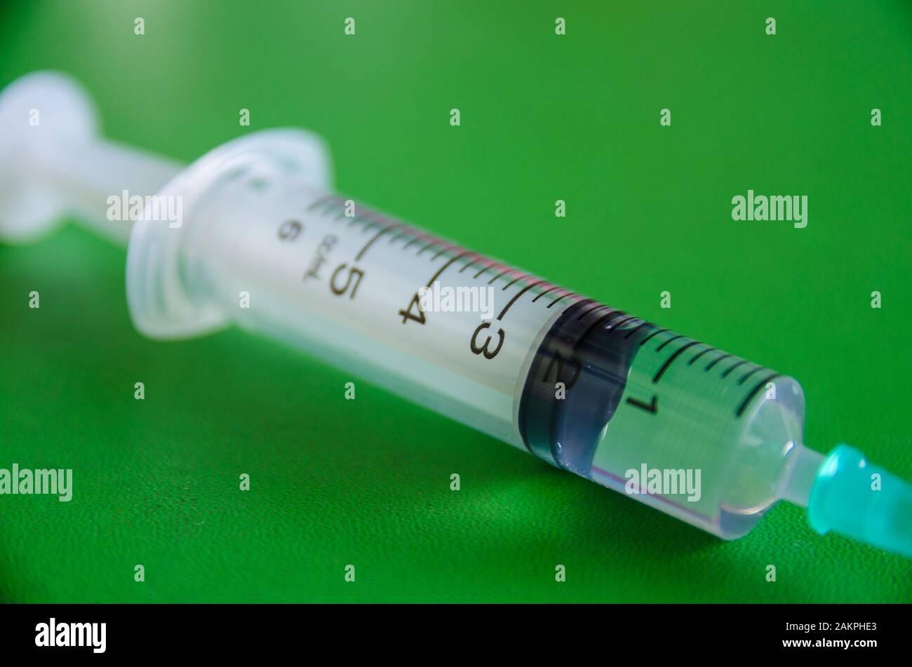 syringe with liquid drug on green table Stock Photo - Alamy