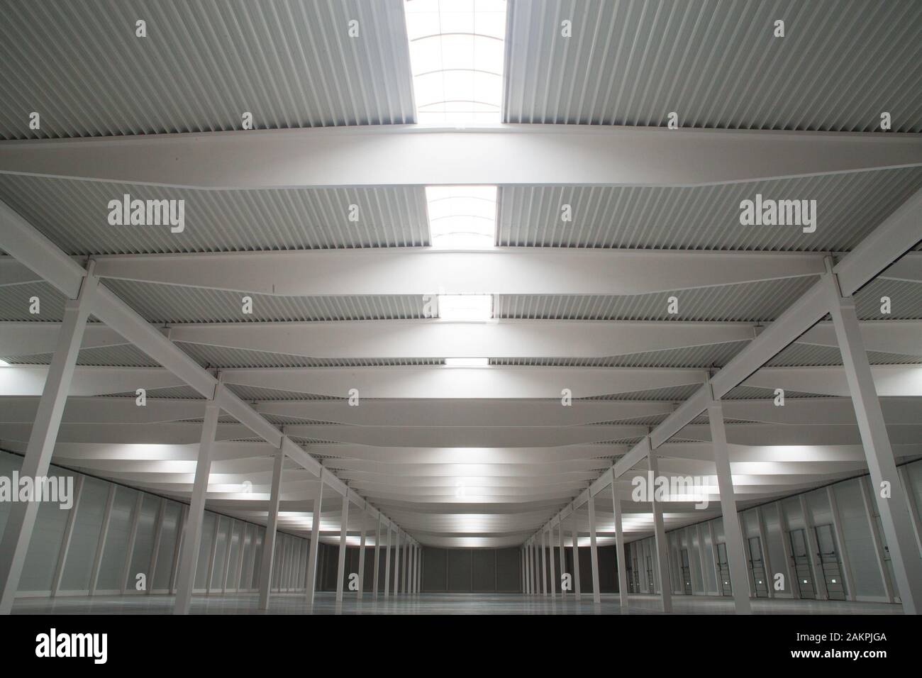 empty warehouse with white floor and high ceiling Stock Photo - Alamy
