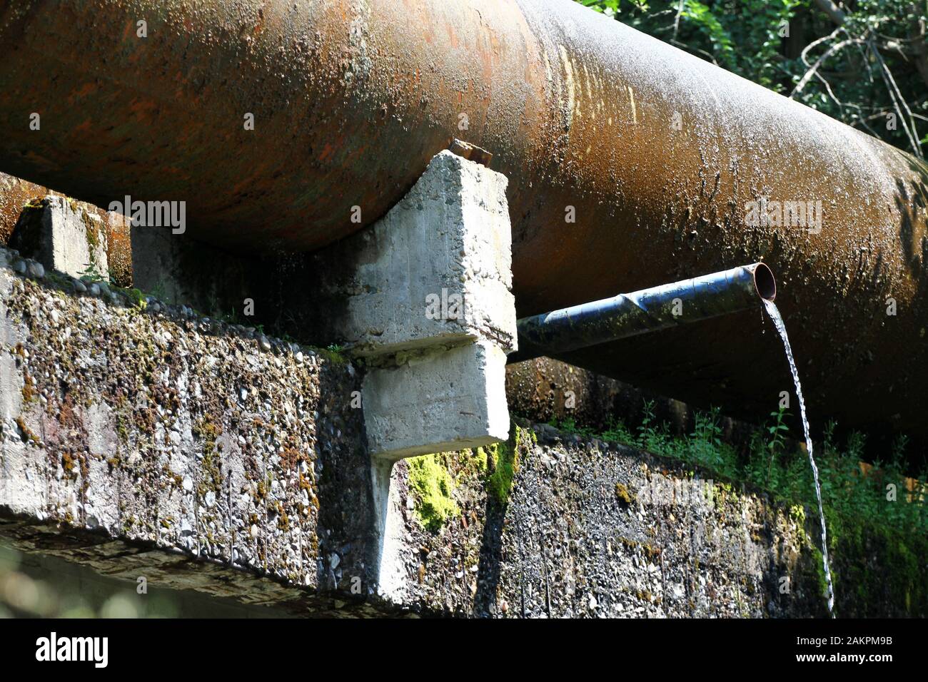 Rusty, cracked pipes spray water in nature. Water supply network Stock ...