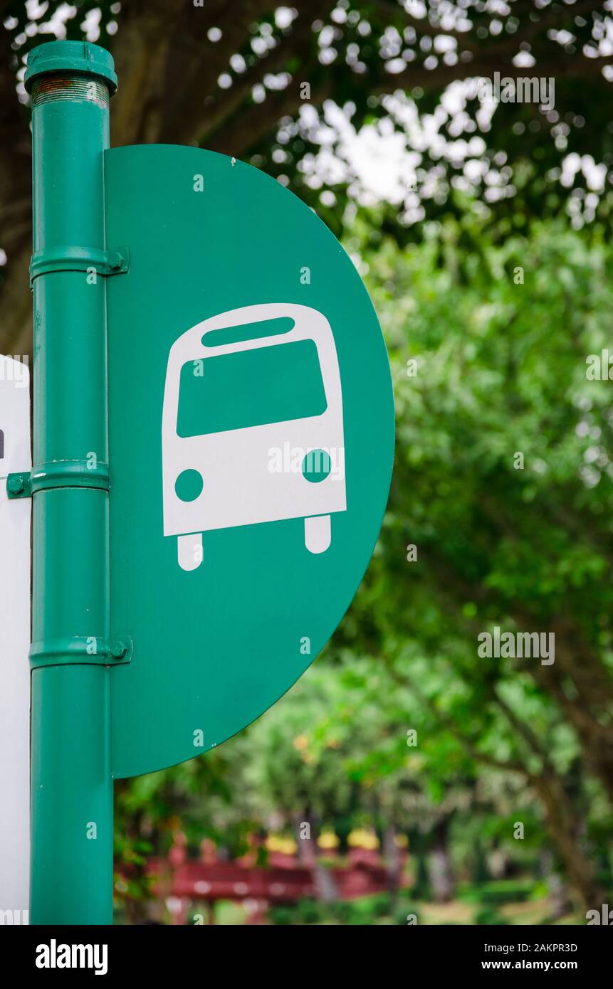 bus stop pole in green tree background Stock Photo - Alamy