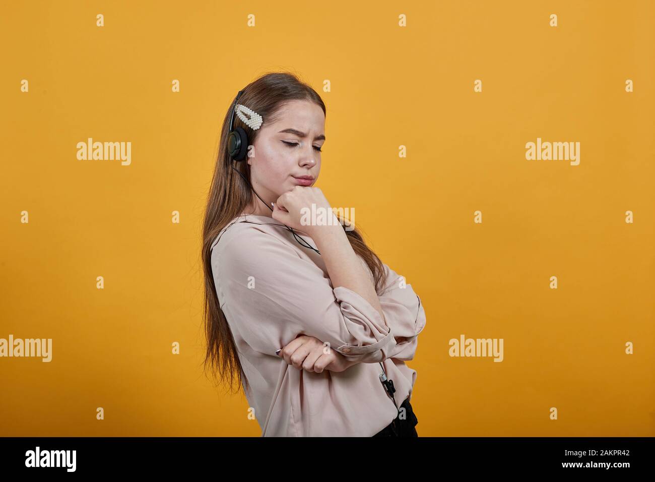 Disappointed woman keeping fingers over chin, holding other hand on ...