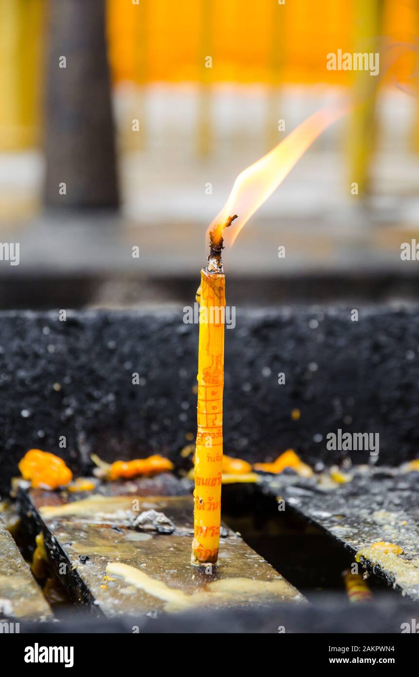 yellow thai buddha candle is burning Stock Photo - Alamy