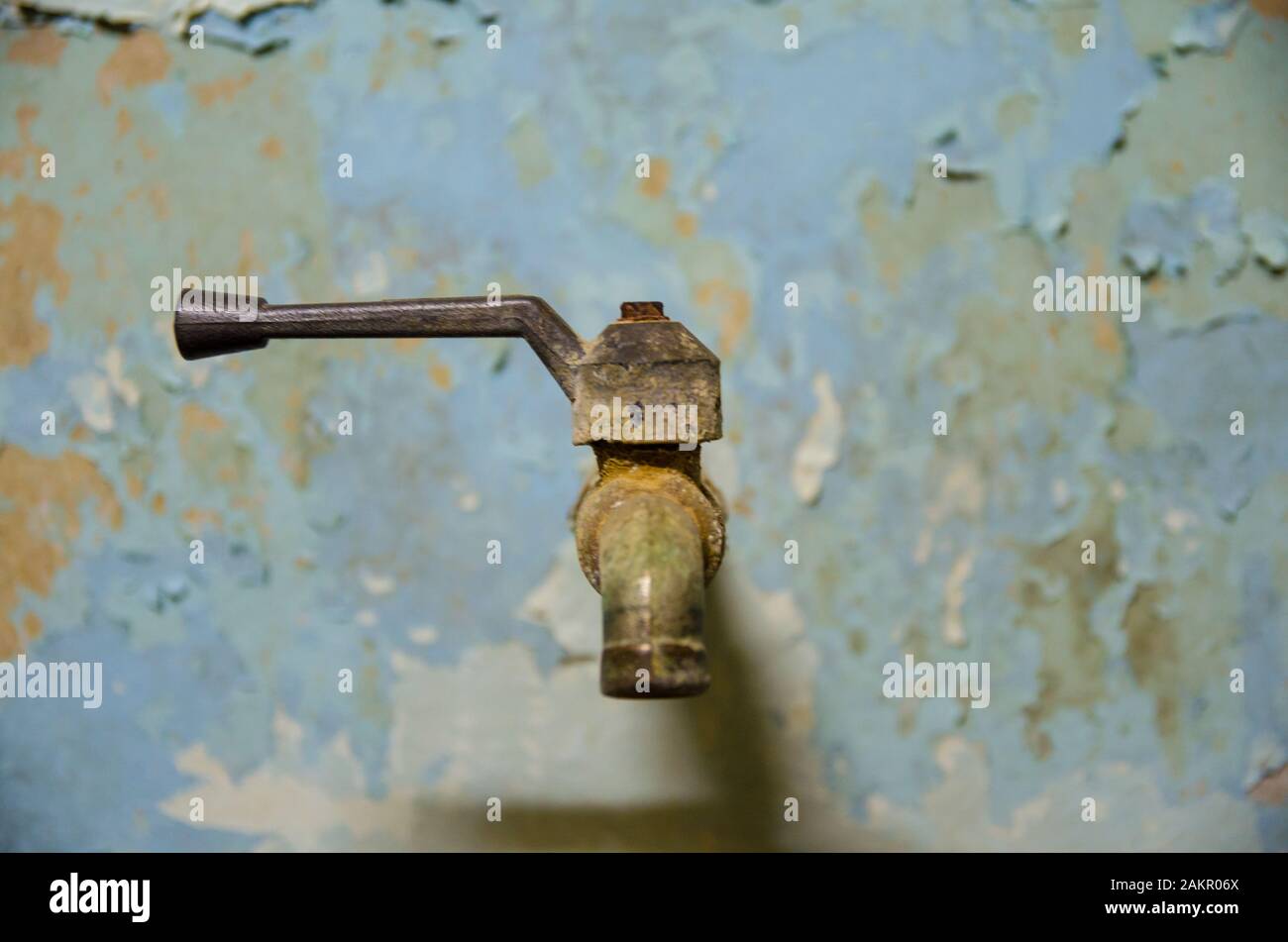 old rusty water tap on pale wall in front view Stock Photo - Alamy