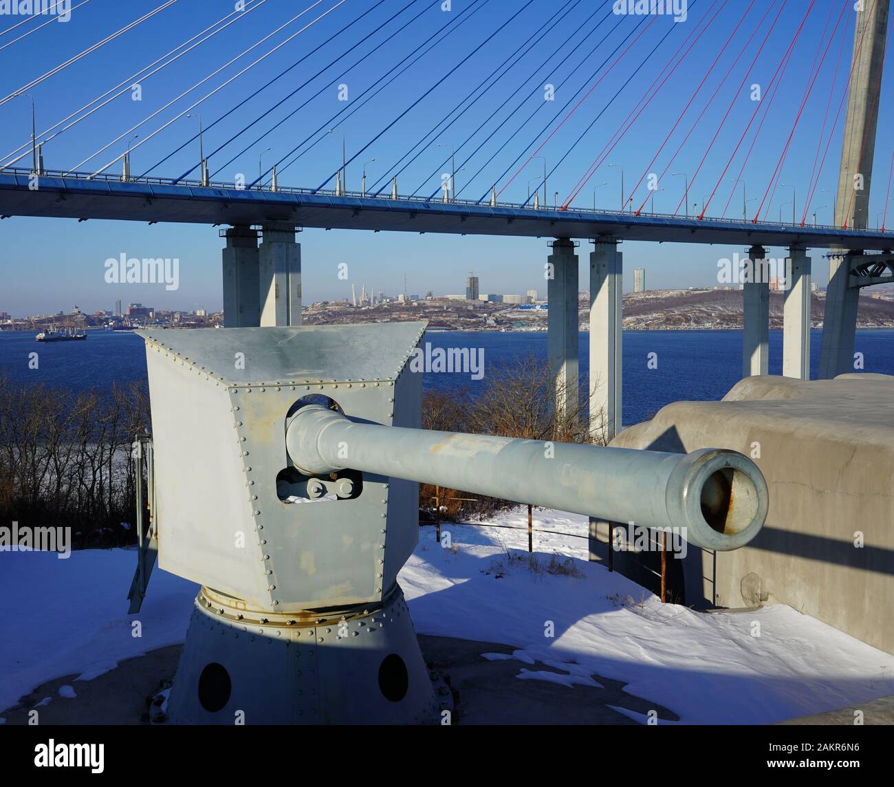 The barrel of a gun on the background of the Russian bridge ...