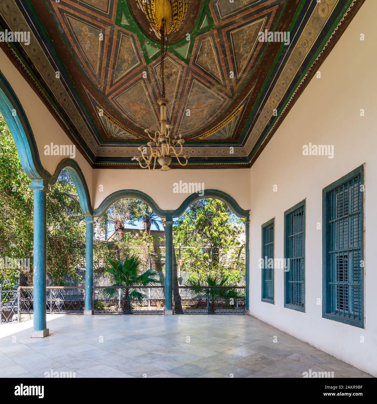 Covered terrace with decorated painted ceiling, green stone pillars ...