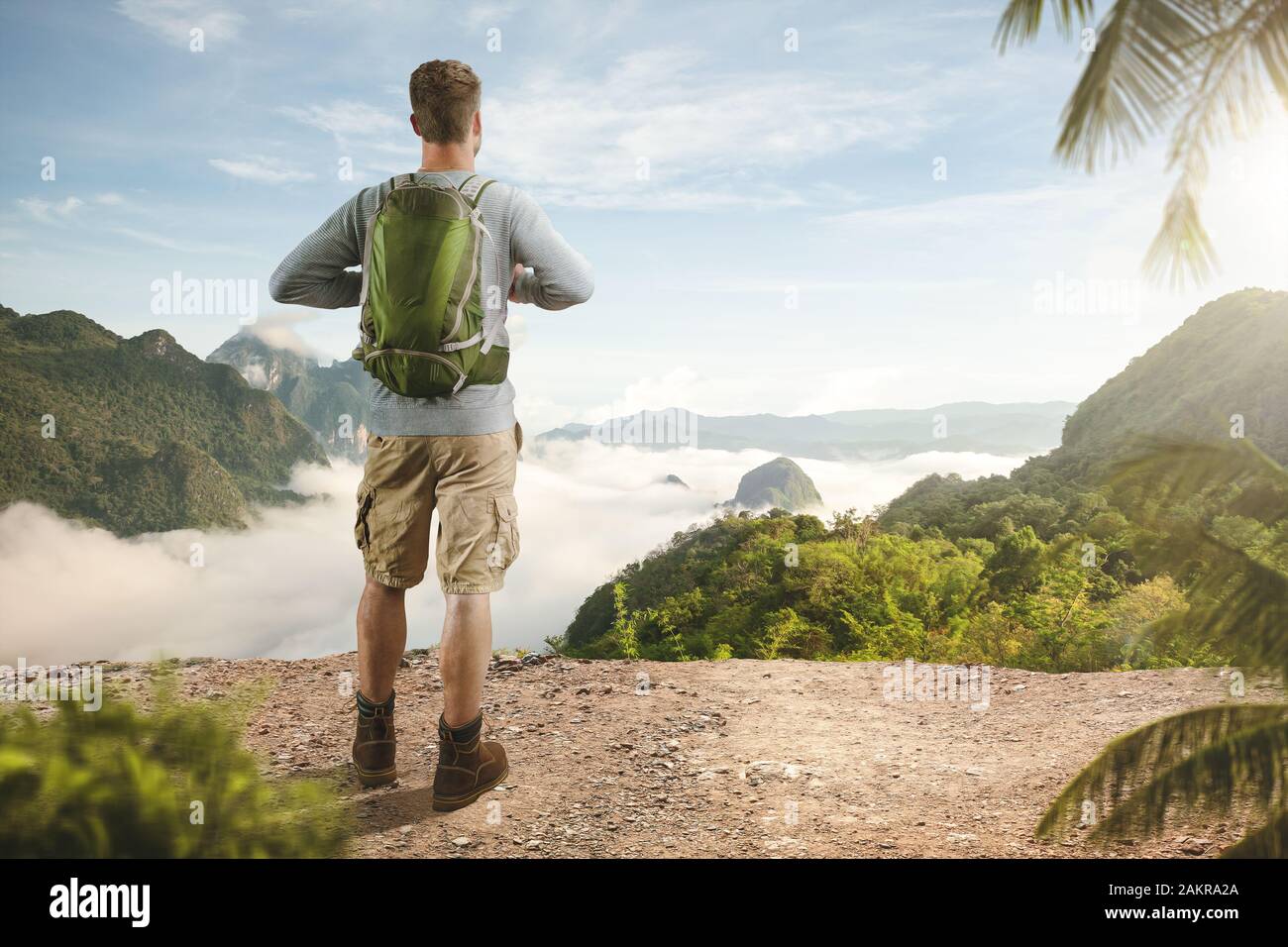 Hiker on a mountain overlooking a tropical landscape Stock Photo - Alamy
