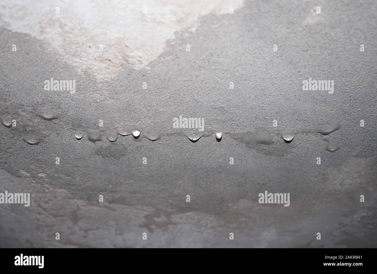 damage caused by dampness and moisture on a ceiling, with droplets of ...