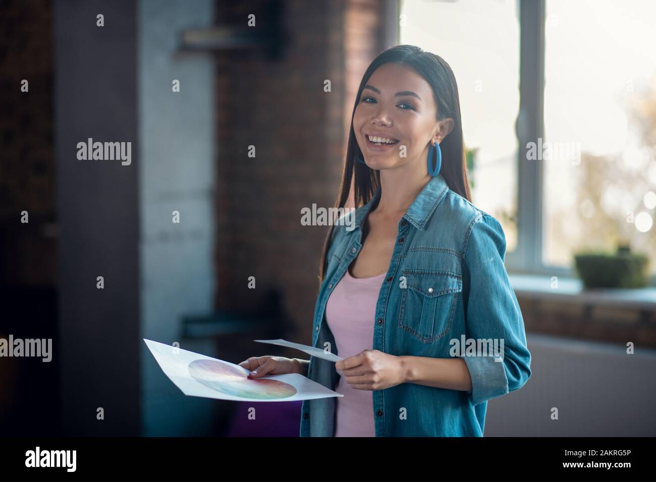 Happy Asian woman standing against the window Stock Photo - Alamy