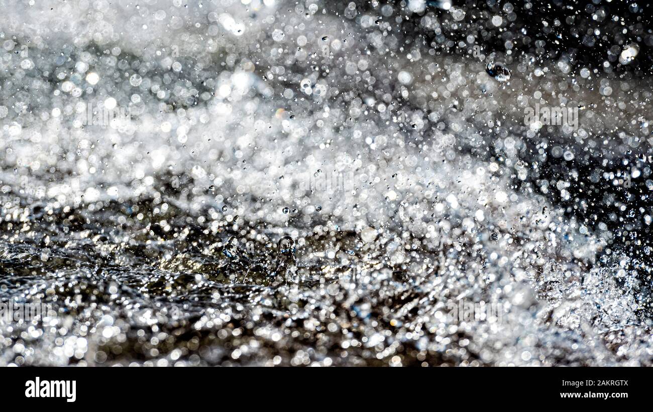 Water splash with small drops in the fountain. Abstract natural ...
