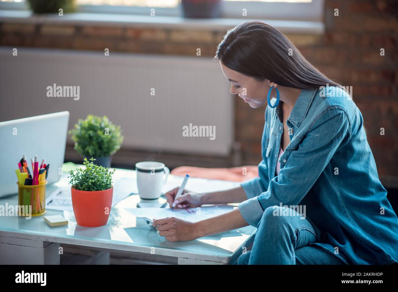 Happy good looking nice woman taking notes Stock Photo - Alamy