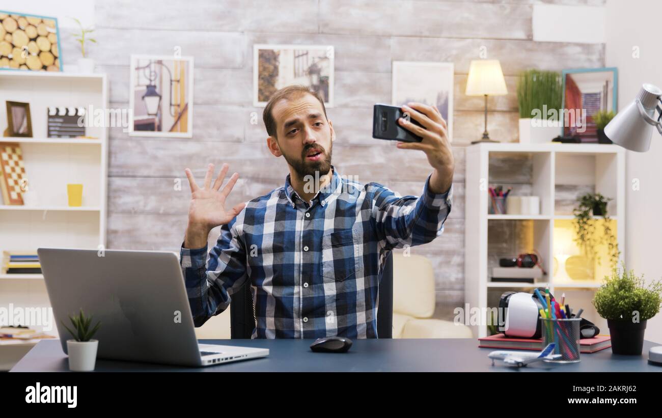 Creative young man using his phone to record a new episode for social ...