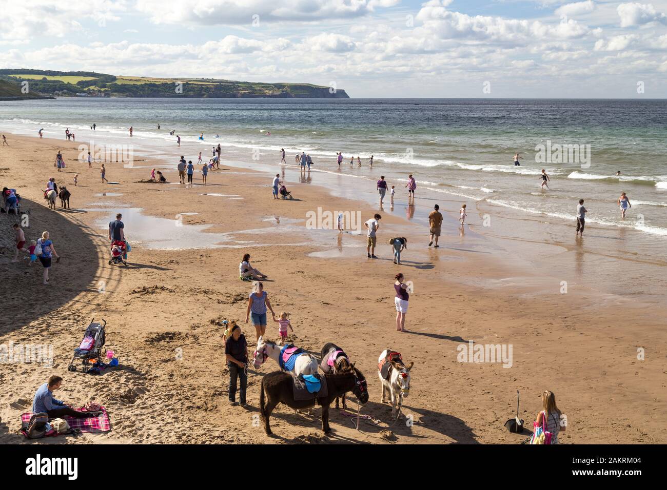People enjoying the sunshine on Whitby beach Stock Photo - Alamy