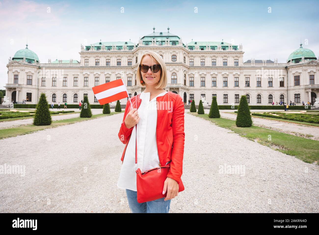 A young female tourist with the Austrian flag enjoys a tour of Vienna ...