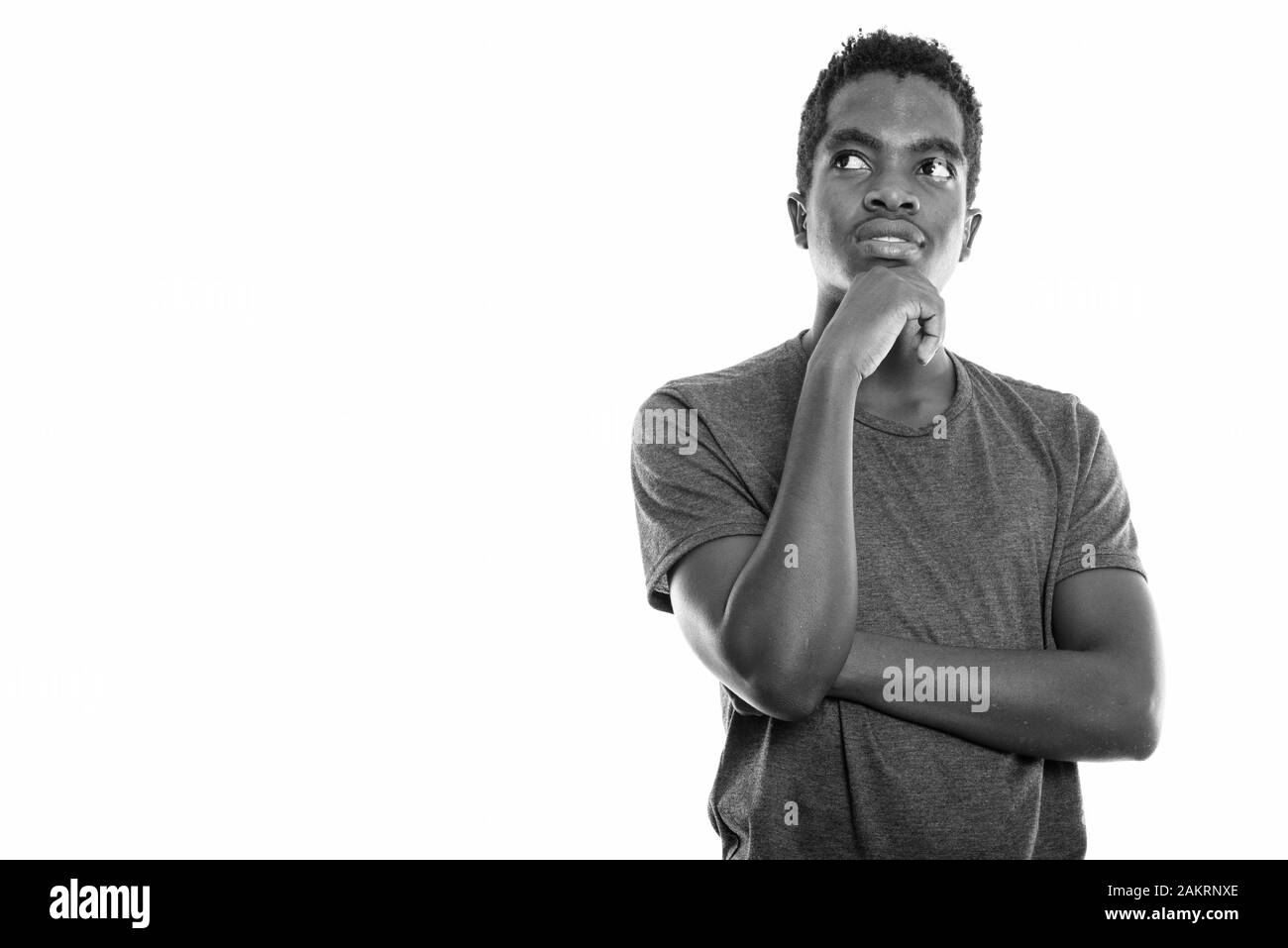 Studio shot of young black African teenage boy thinking while looking ...