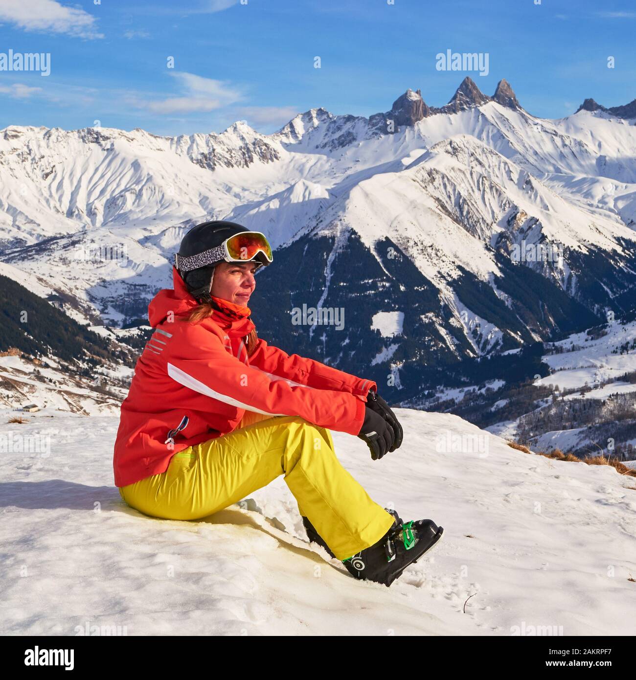 Woman skier enjoying the sun on the slopes of Les Sybelles ski domain ...