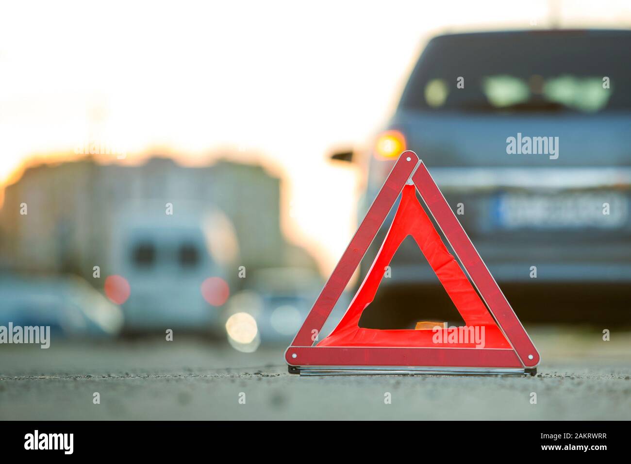 Red emergency triangle stop sign and broken car on a city street Stock ...
